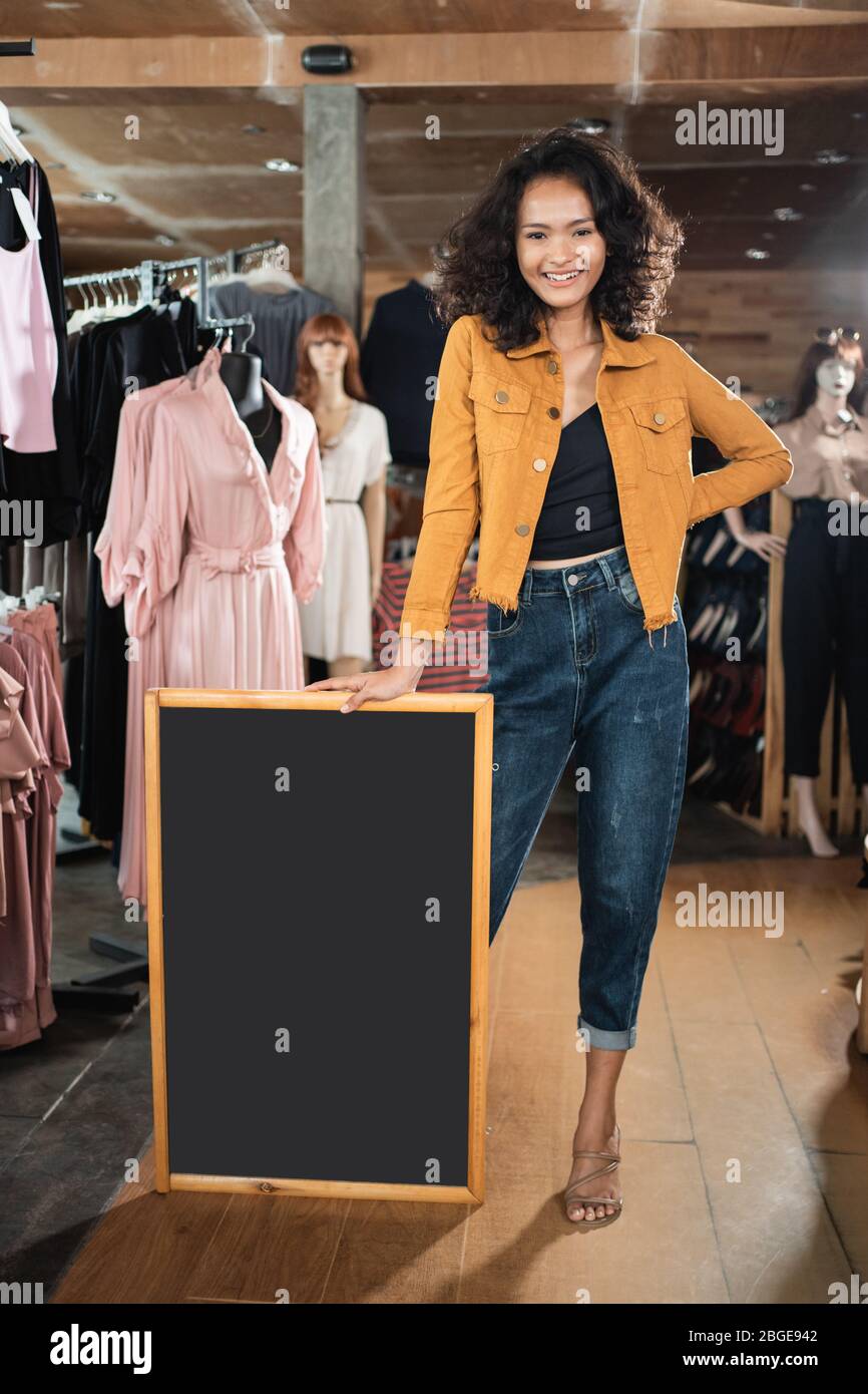 attractive young business owner holding chalkboard with 50 percent ...