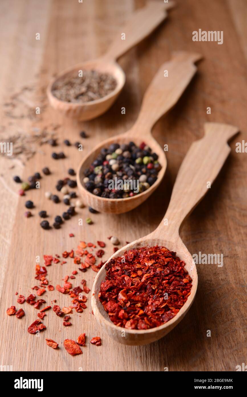 Different spices in spoons on wooden background Stock Photo - Alamy