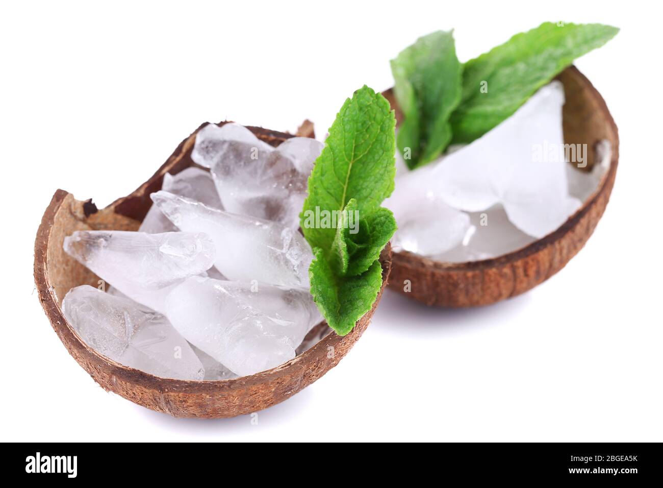 Fruit slices and ice cubes in coconut shell isolated on white. Cold ...