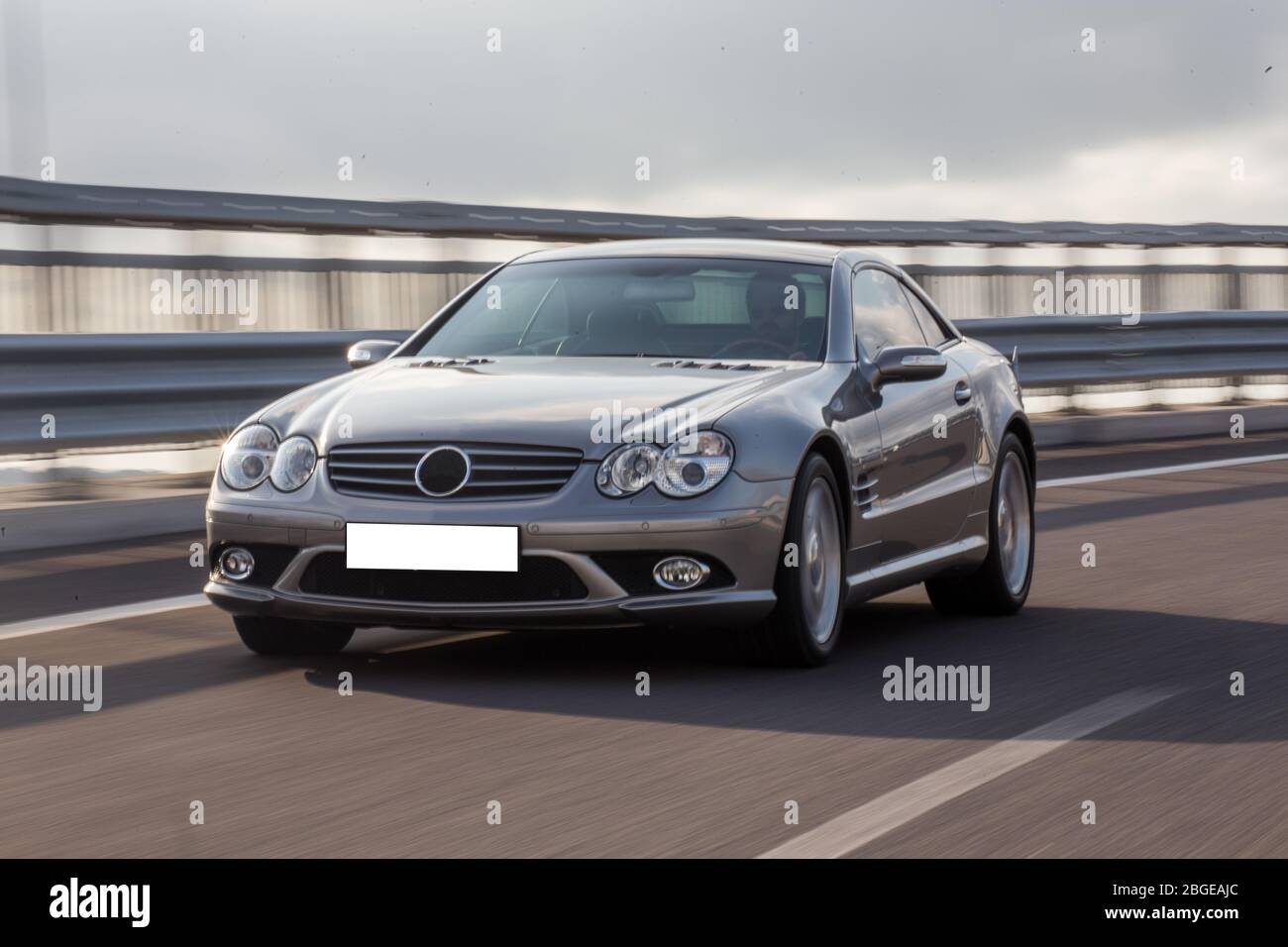 Black cabriolet touring on the highway in a hot sumer day,front view ...