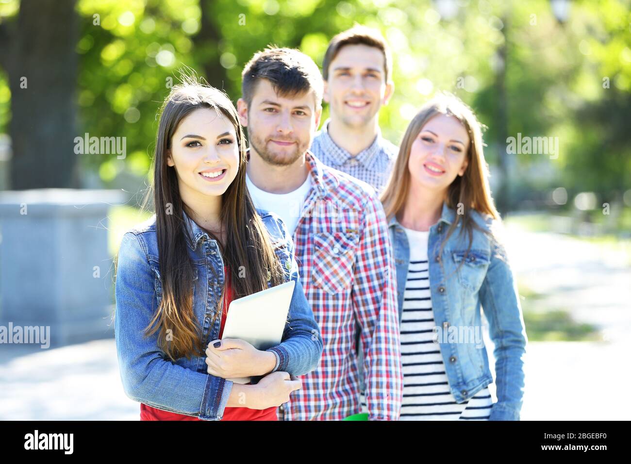 Happy students in park Stock Photo - Alamy