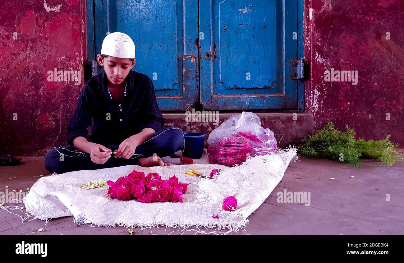 A young muslim boy selling flowers at Russel market Stock Photo - Alamy