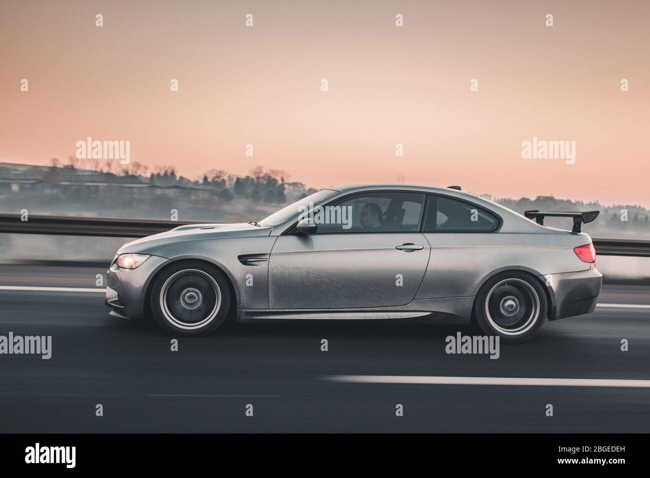 Grey modern sedan test drive on the highway, profile view Stock Photo ...