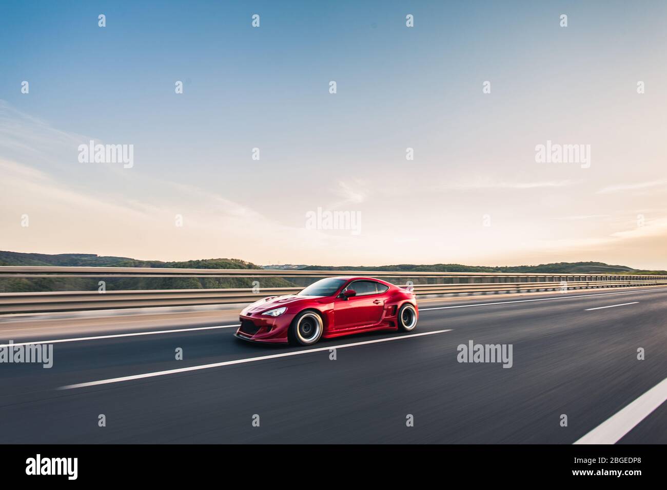 Red racing car on the highway in a sunny day Stock Photo - Alamy