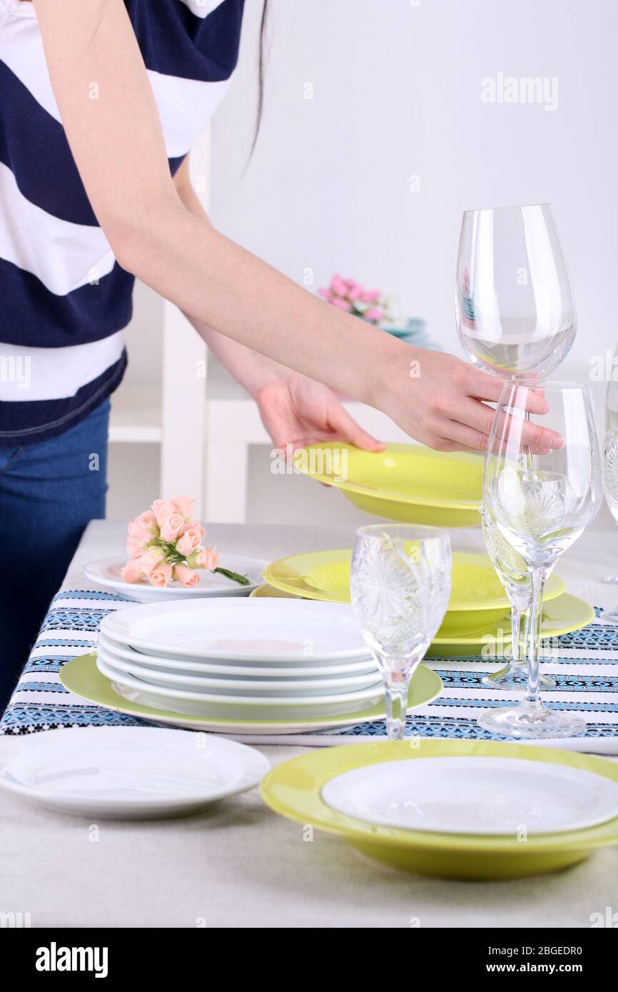Woman laying table in room Stock Photo - Alamy