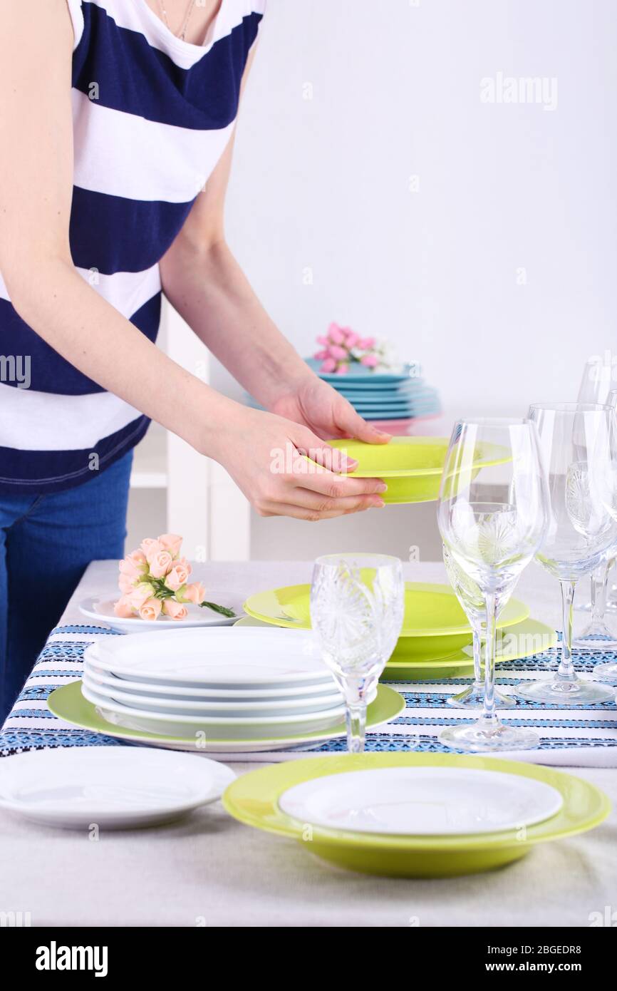 Woman laying table in room Stock Photo - Alamy