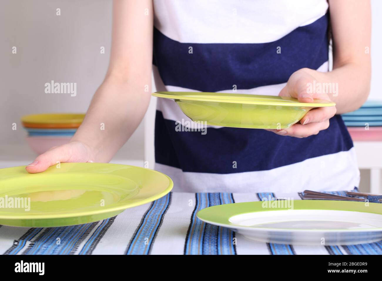 Woman laying table in room Stock Photo - Alamy