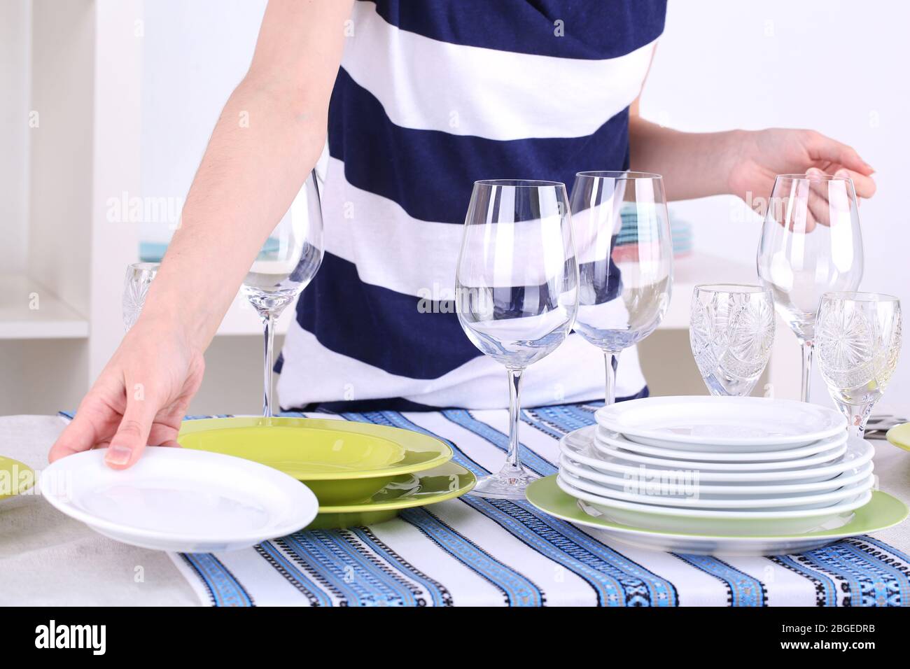 Woman laying table in room Stock Photo - Alamy