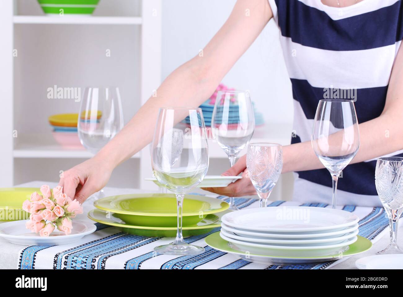 Woman laying table in room Stock Photo - Alamy