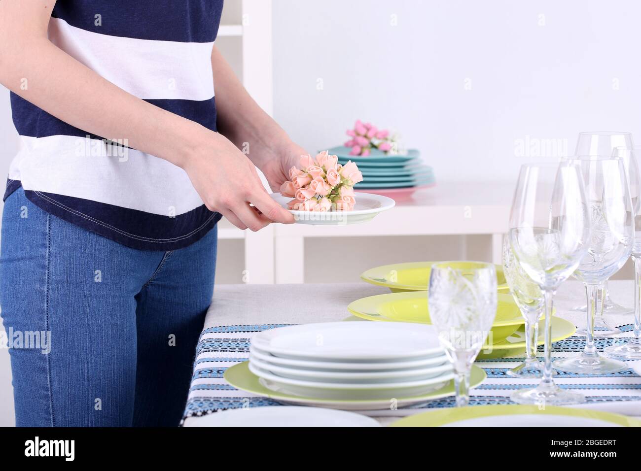 Woman laying table in room Stock Photo - Alamy