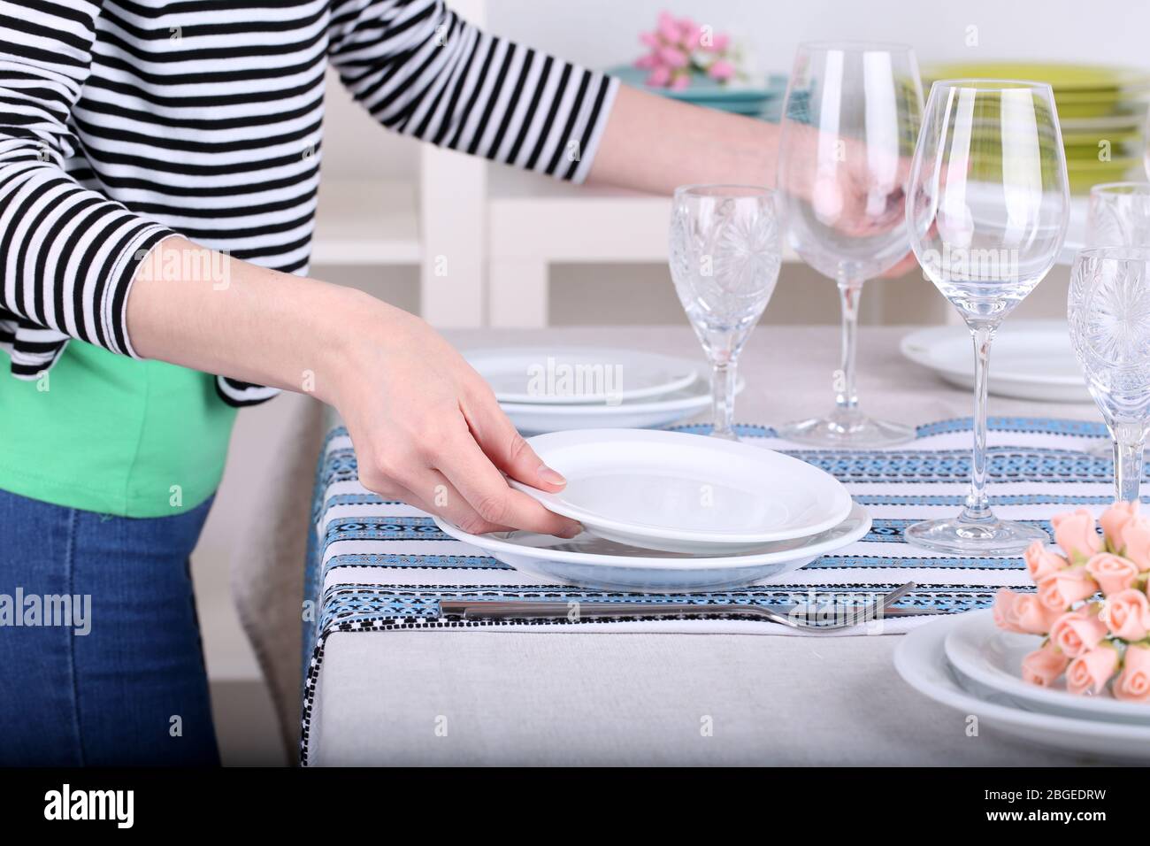 Woman laying table in room Stock Photo - Alamy
