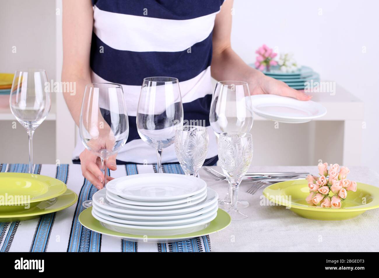 Woman laying table in room Stock Photo - Alamy