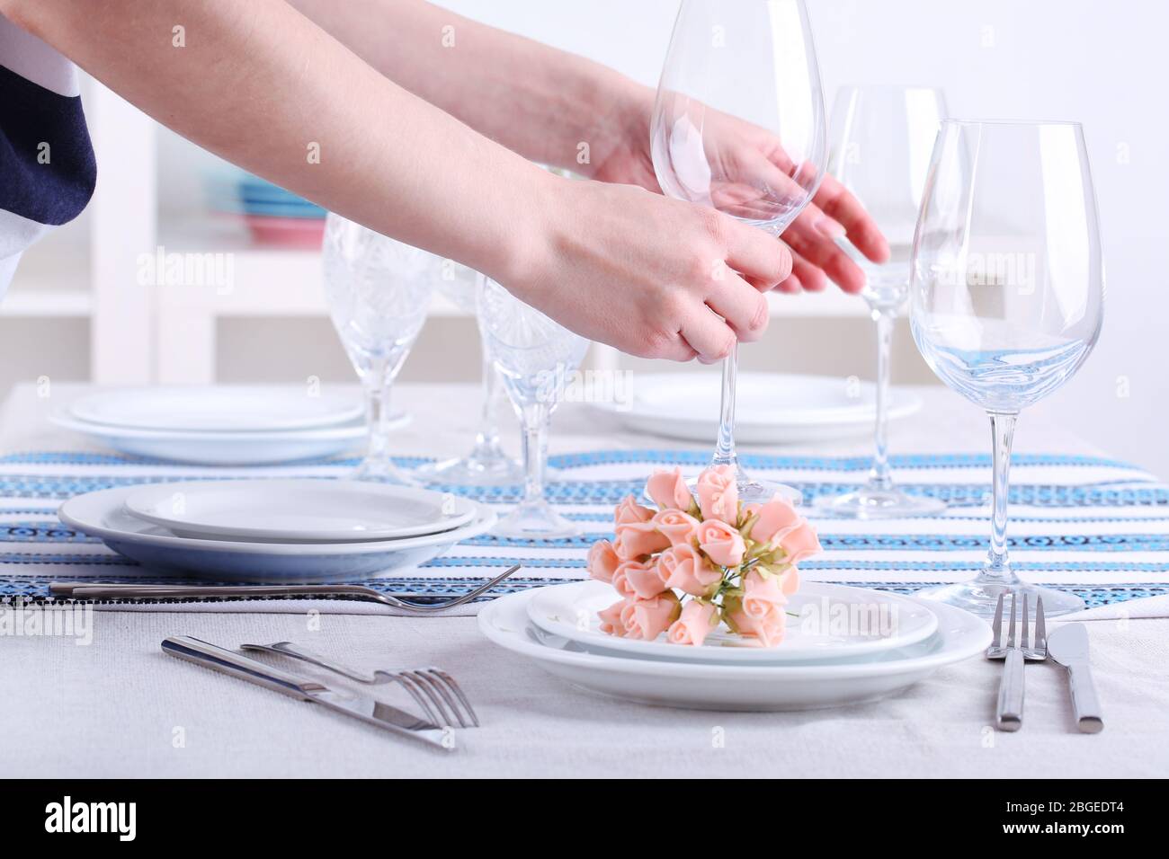 Woman laying table in room Stock Photo - Alamy