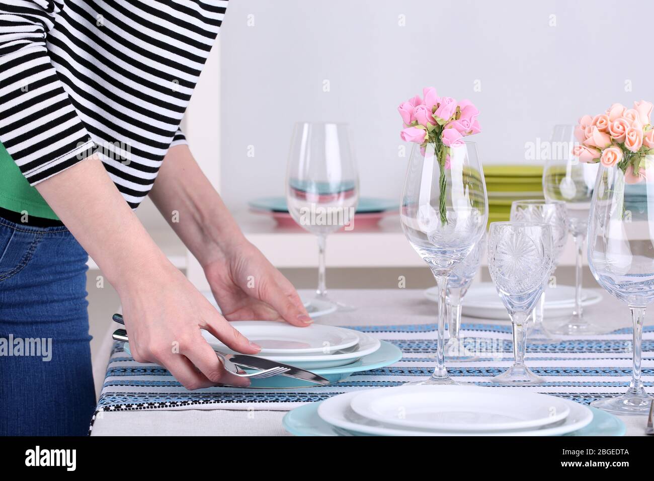 Woman laying table in room Stock Photo - Alamy