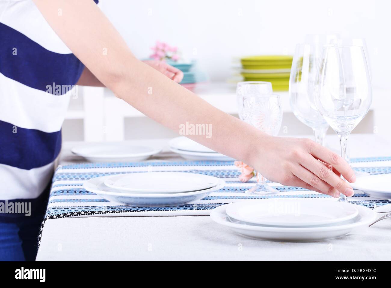 Woman laying table in room Stock Photo - Alamy