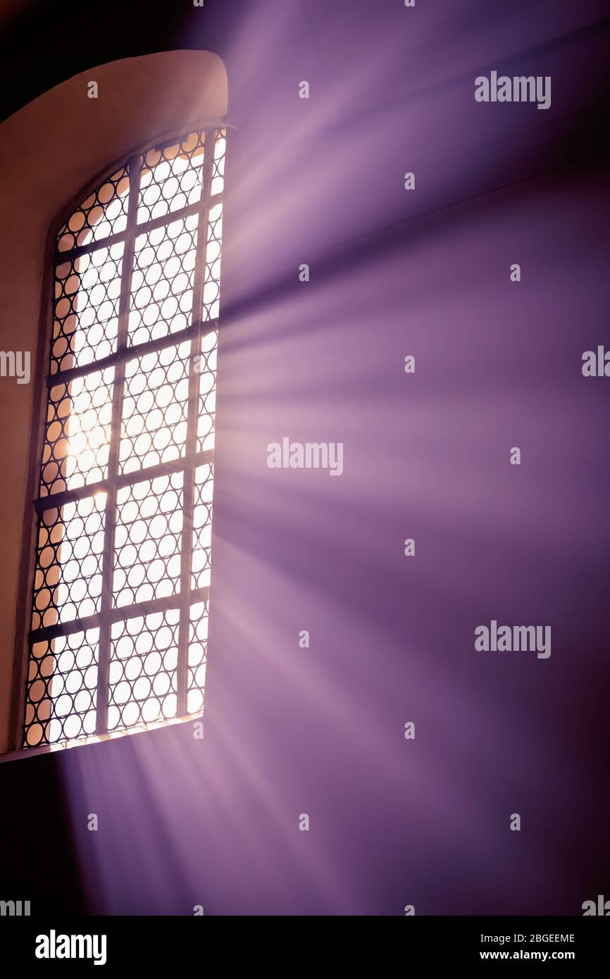 Purple light rays through the black window Stock Photo - Alamy