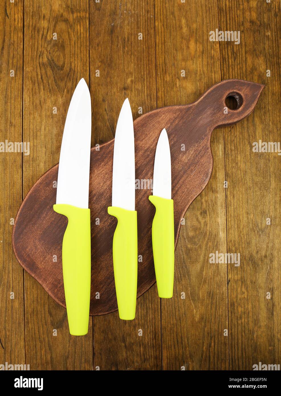 Kitchen knives and cutting board on wooden table Stock Photo - Alamy