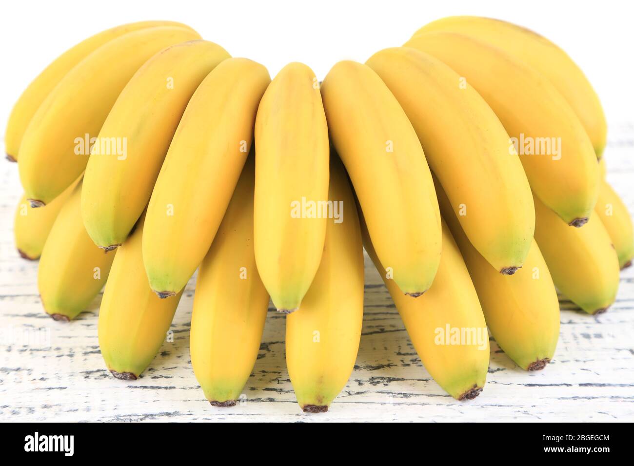 Bunch of mini bananas on color wooden background Stock Photo - Alamy