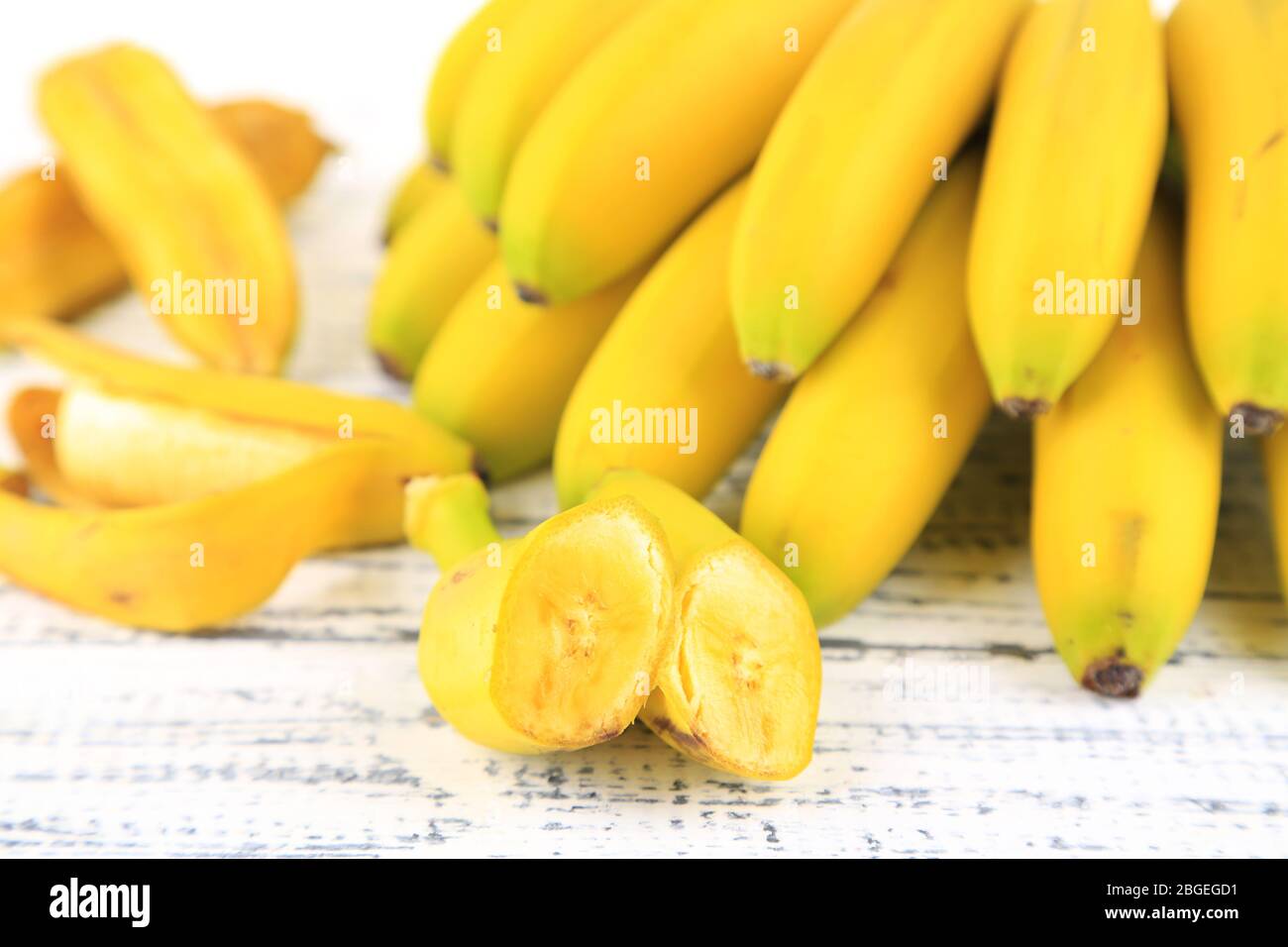 Bunch of mini bananas on color wooden background Stock Photo - Alamy