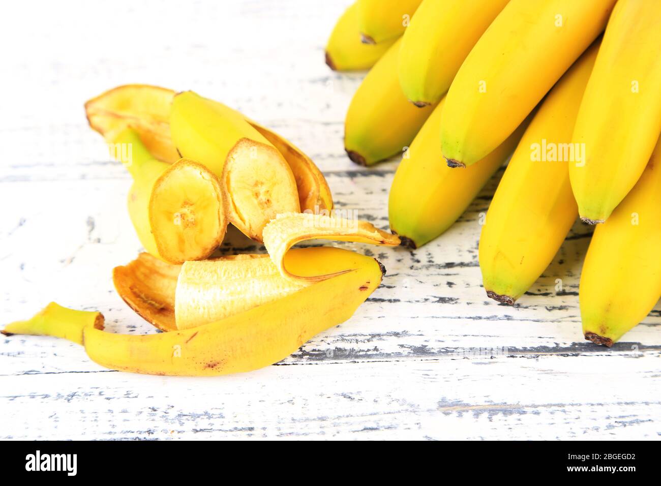 Bunch of mini bananas on color wooden background Stock Photo - Alamy