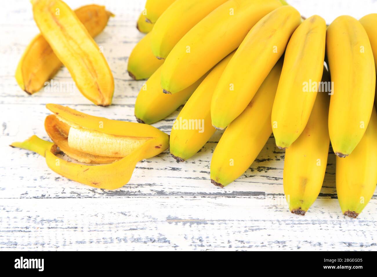 Bunch of mini bananas on color wooden background Stock Photo - Alamy