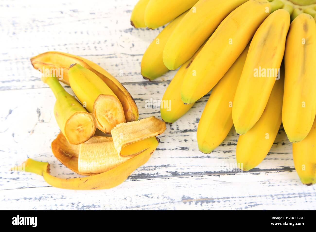 Bunch of mini bananas on color wooden background Stock Photo - Alamy