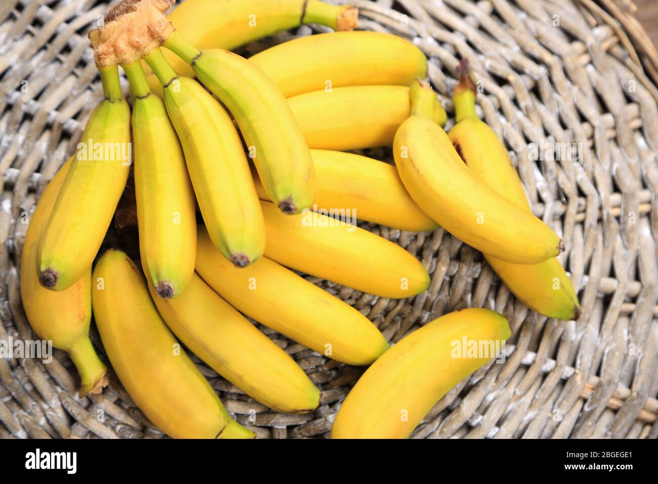 Bunch of mini bananas on wicker mat background Stock Photo - Alamy
