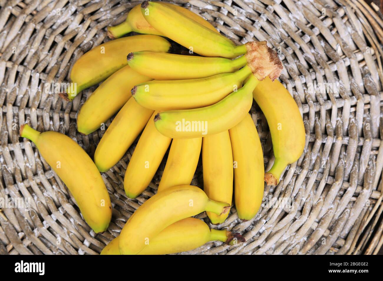 Bunch of mini bananas on wicker mat background Stock Photo - Alamy