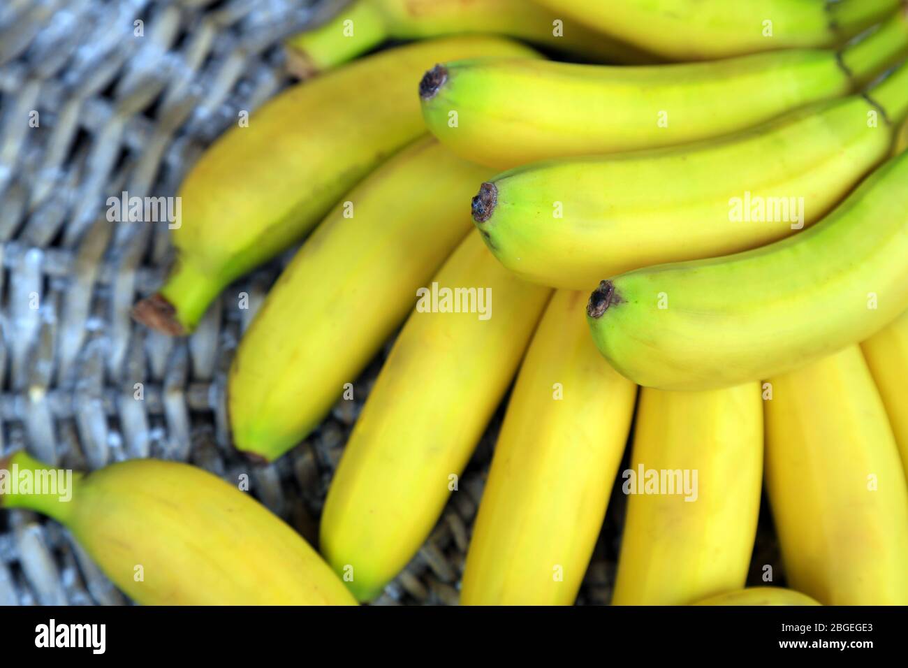 Bunch of mini bananas on wicker mat background Stock Photo - Alamy