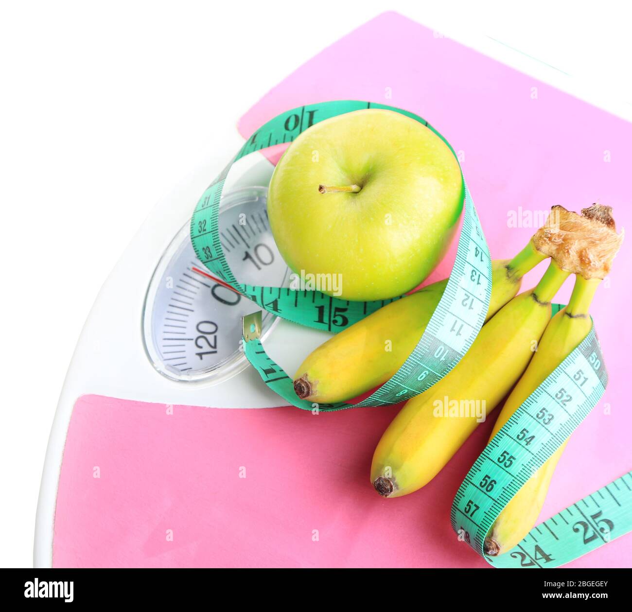 Bunch of mini bananas and measuring tape on scales, isolated on white ...