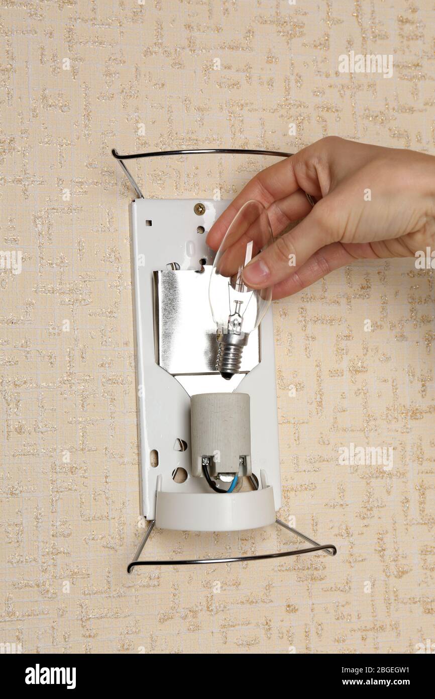 Hand changing light bulb at home Stock Photo - Alamy
