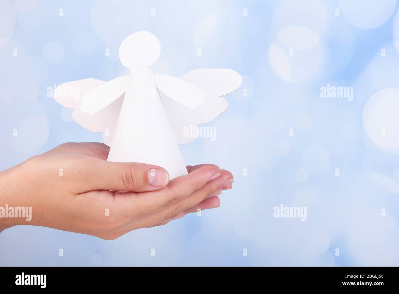 Christmas angel in hand on bright background Stock Photo - Alamy
