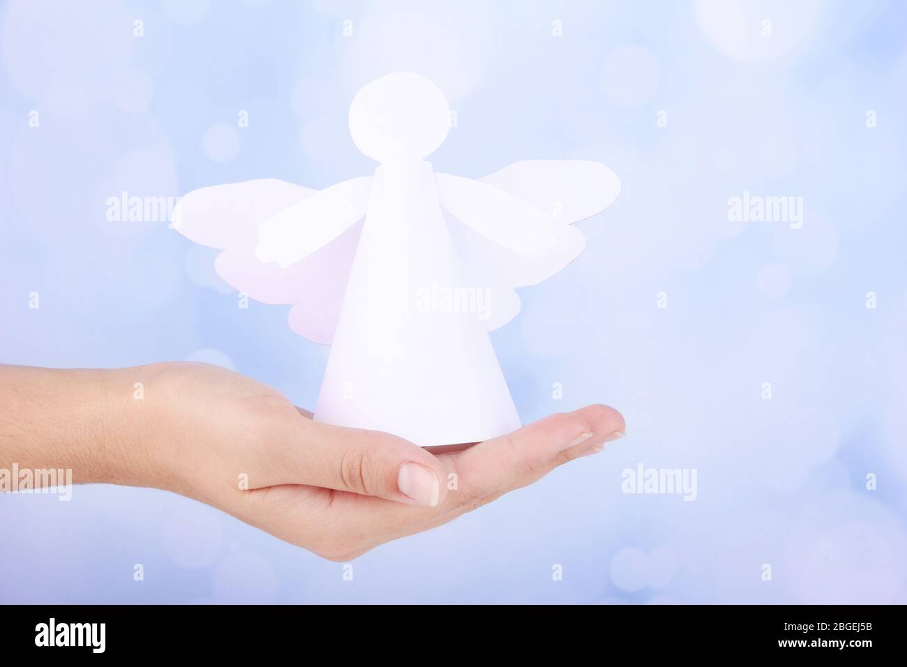 Christmas angel in hand on bright background Stock Photo - Alamy