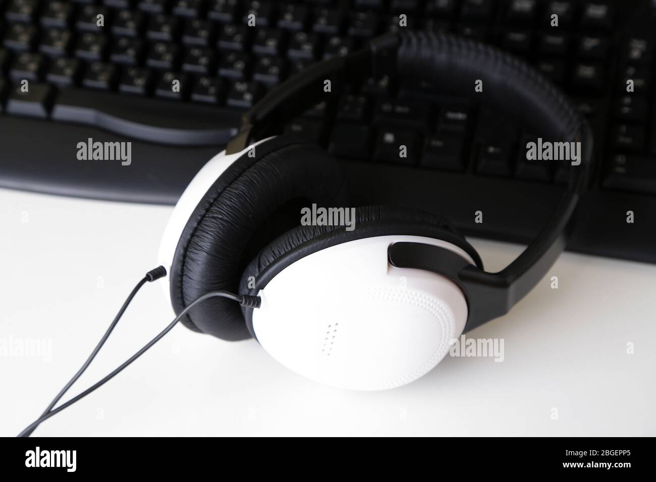 Headphone and keyboard close-up on white desk background Stock Photo ...