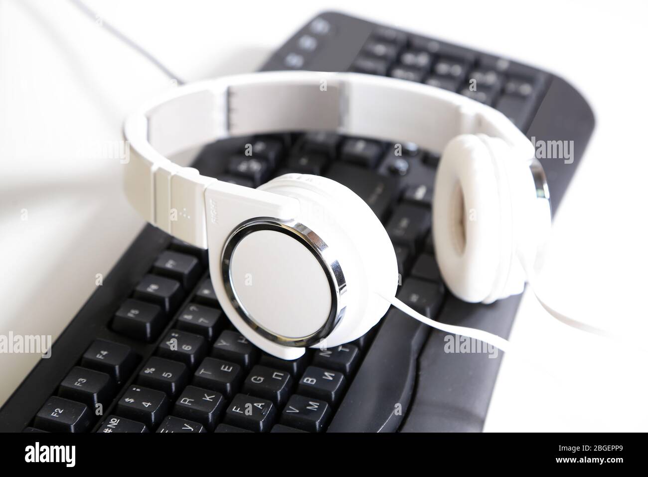Headphone and keyboard close-up on white desk background Stock Photo ...