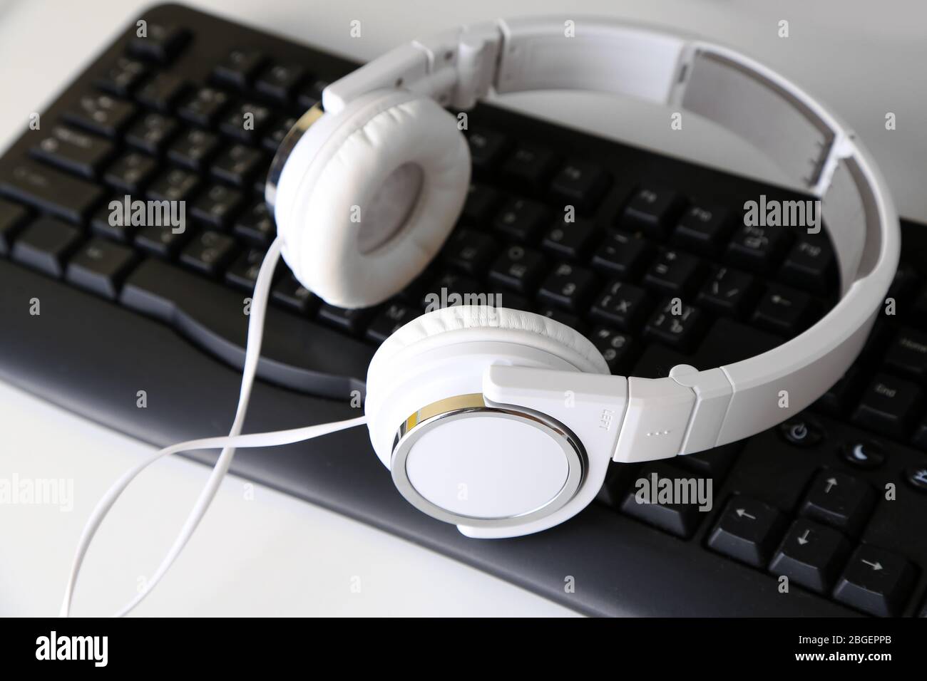 Headphone and keyboard close-up on white desk background Stock Photo ...