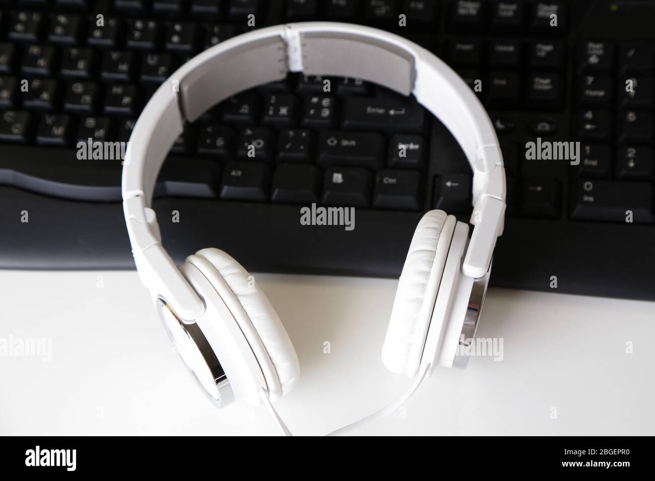 Headphone and keyboard close-up on white desk background Stock Photo ...