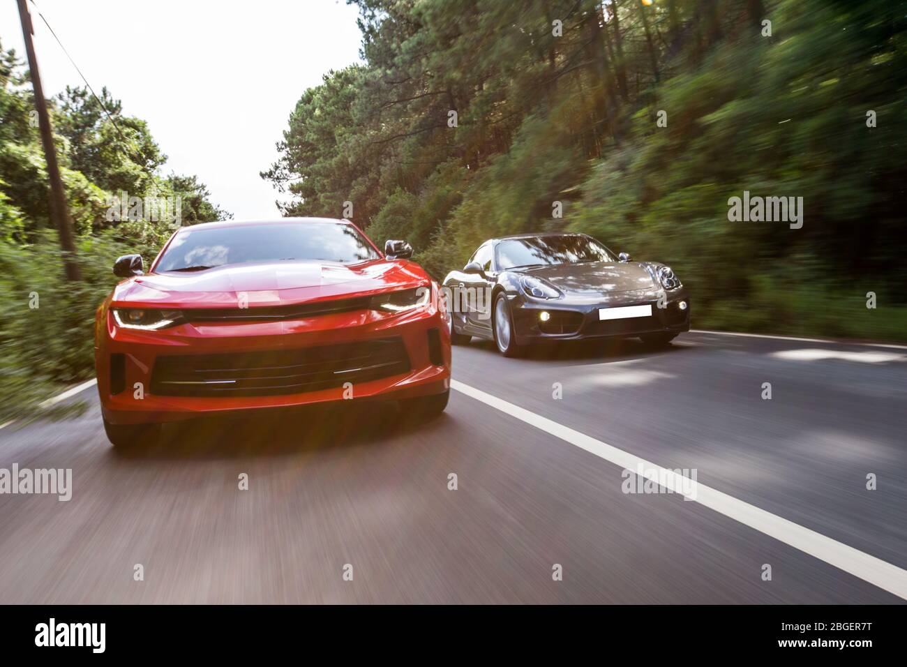 Red and black sport cars passing each other ,speed drive, front view ...