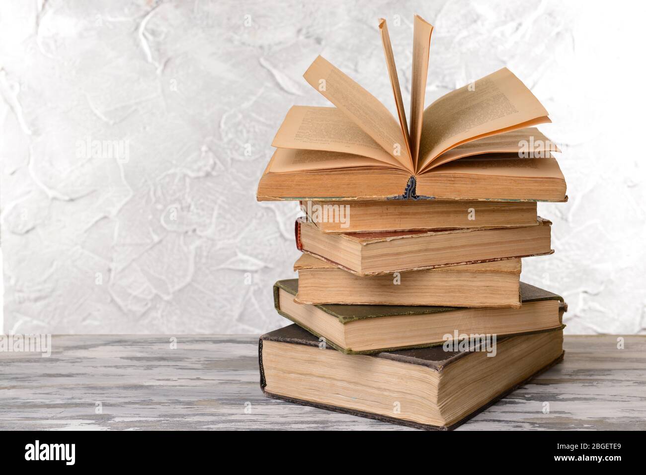 Old books on table on grey background Stock Photo - Alamy