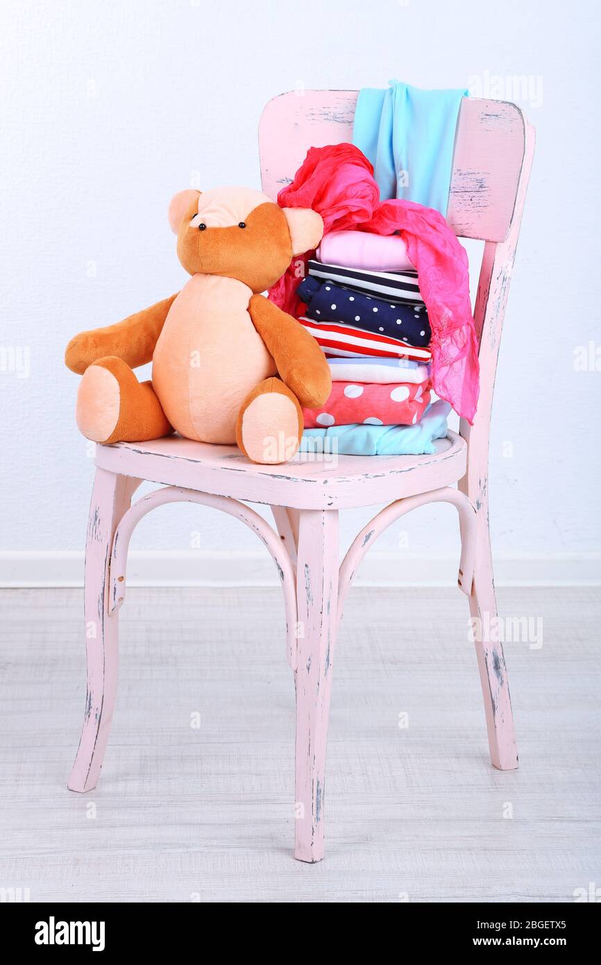 Clothes on chair on gray wall background Stock Photo - Alamy