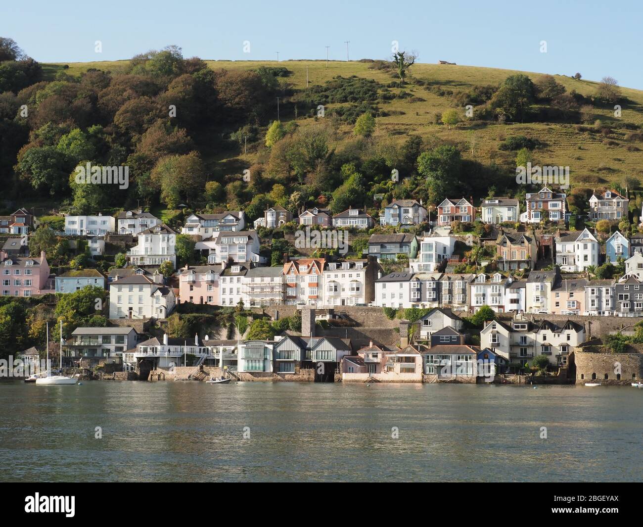 a hill in Kingswear , Devon seen across the River Dart in sunshine ...