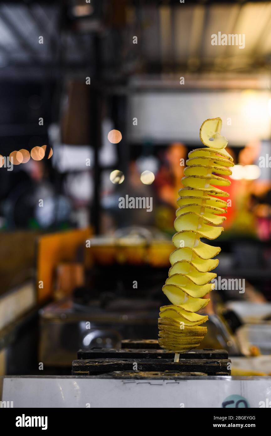 Fried potato springs. Street food on a stick at Thailand night market ...