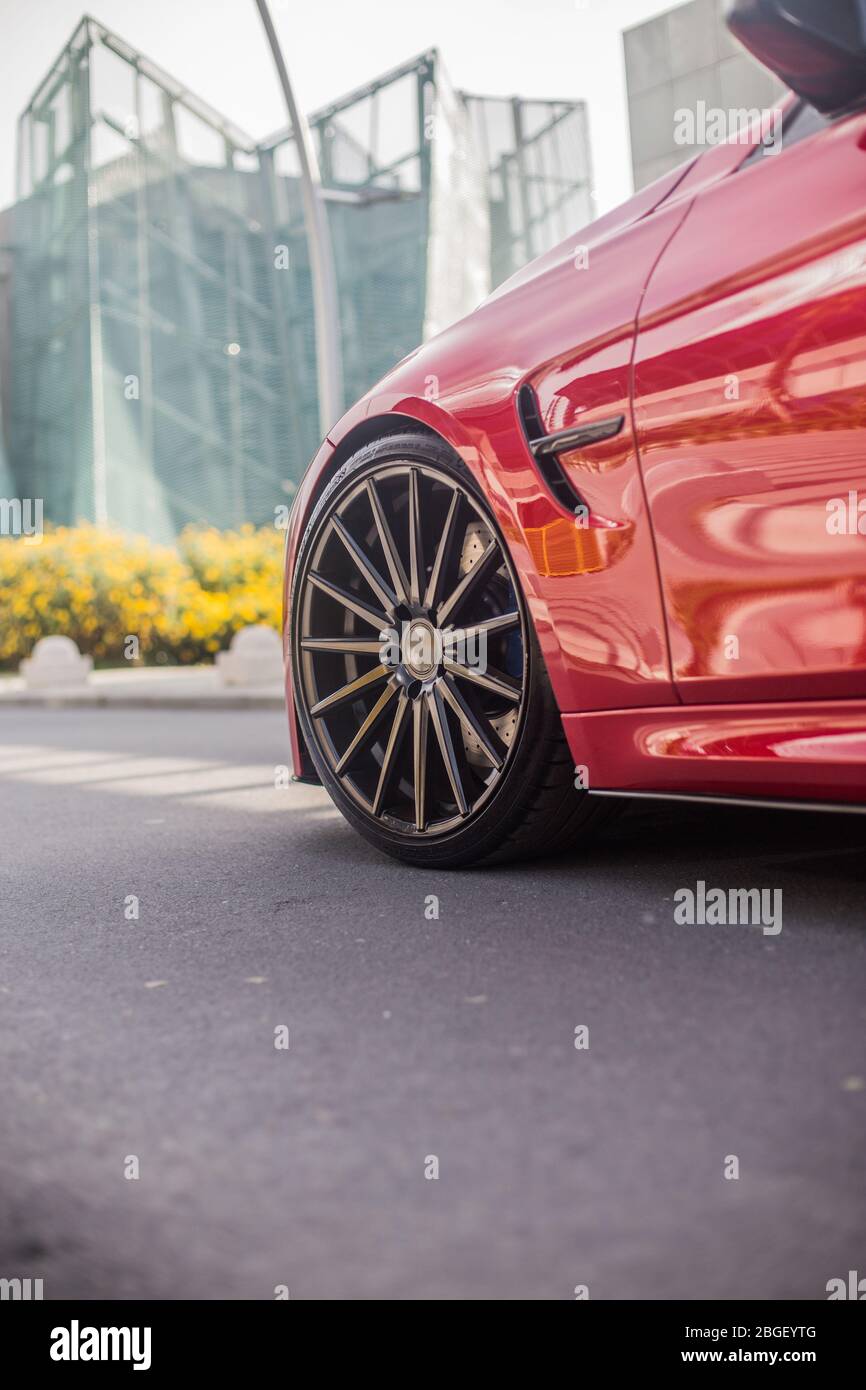 Red model sedan in the business quarter, front wheel view Stock Photo ...