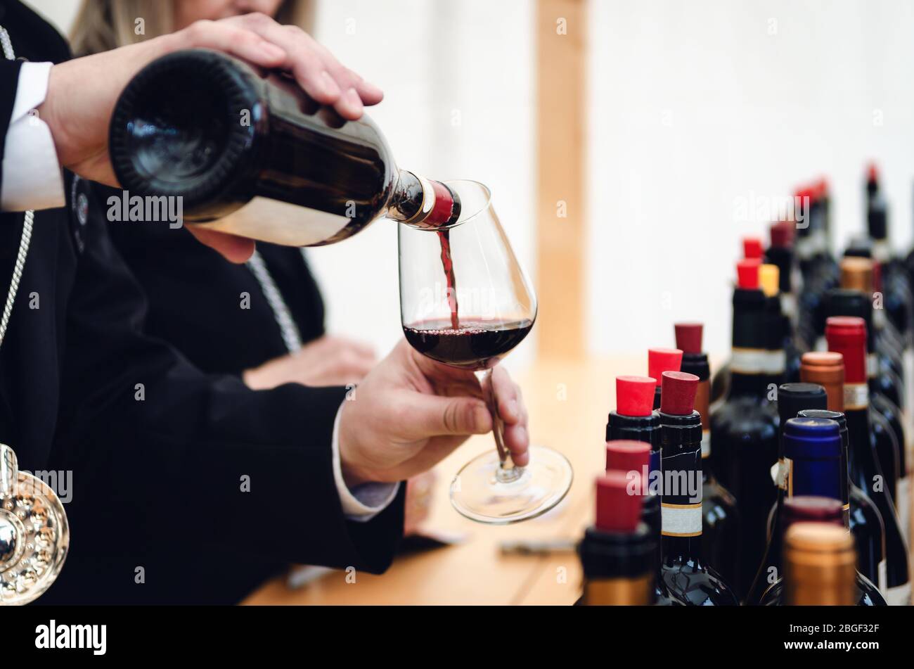 Tasting experience with a male sommelier serving a glass of traditional ...