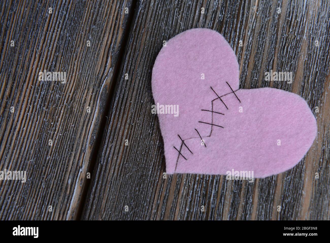 Broken heart and thread on wooden background Stock Photo - Alamy