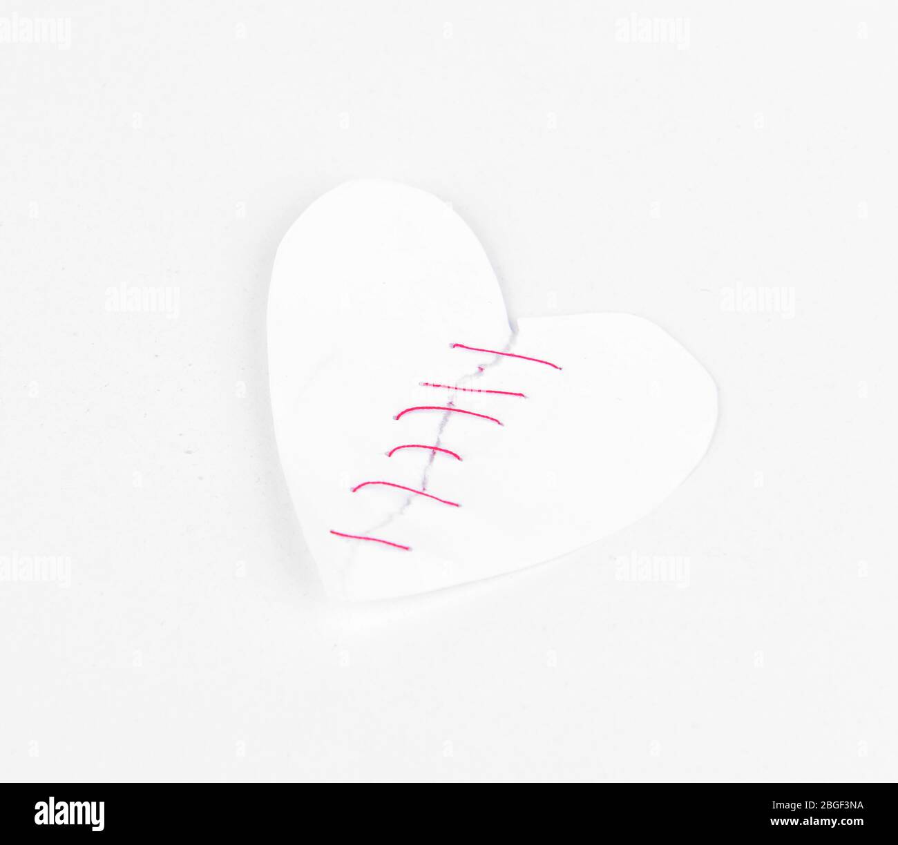 Broken heart and thread isolated on white Stock Photo - Alamy