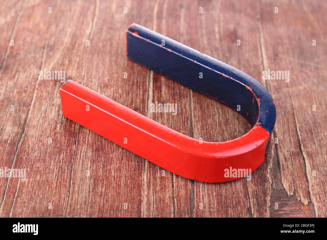 Magnet on color wooden background Stock Photo - Alamy