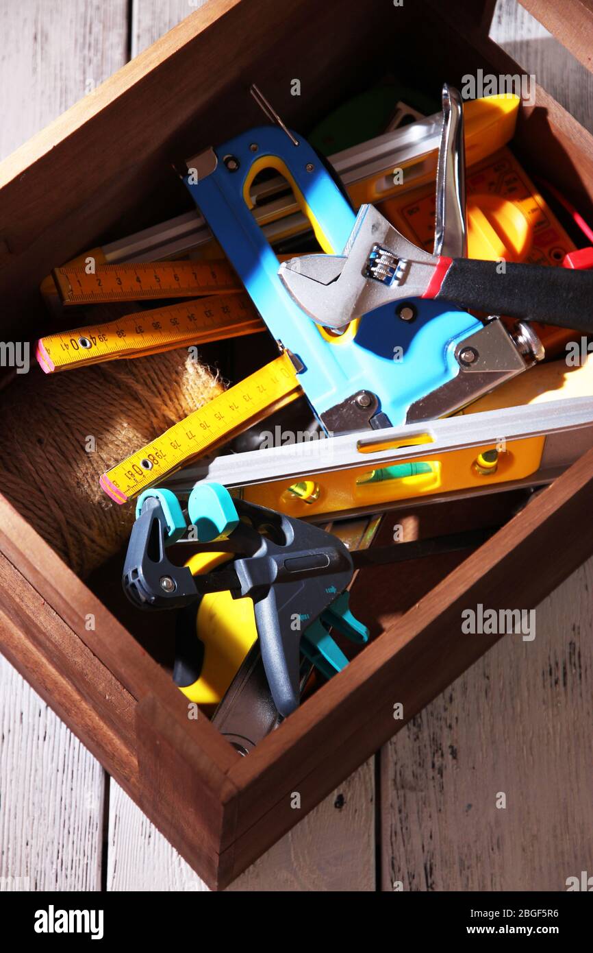 Wooden box with different tools, on wooden background Stock Photo - Alamy