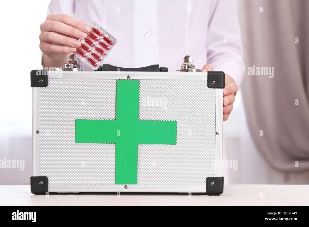 Nurse holding first aid kit in room Stock Photo - Alamy