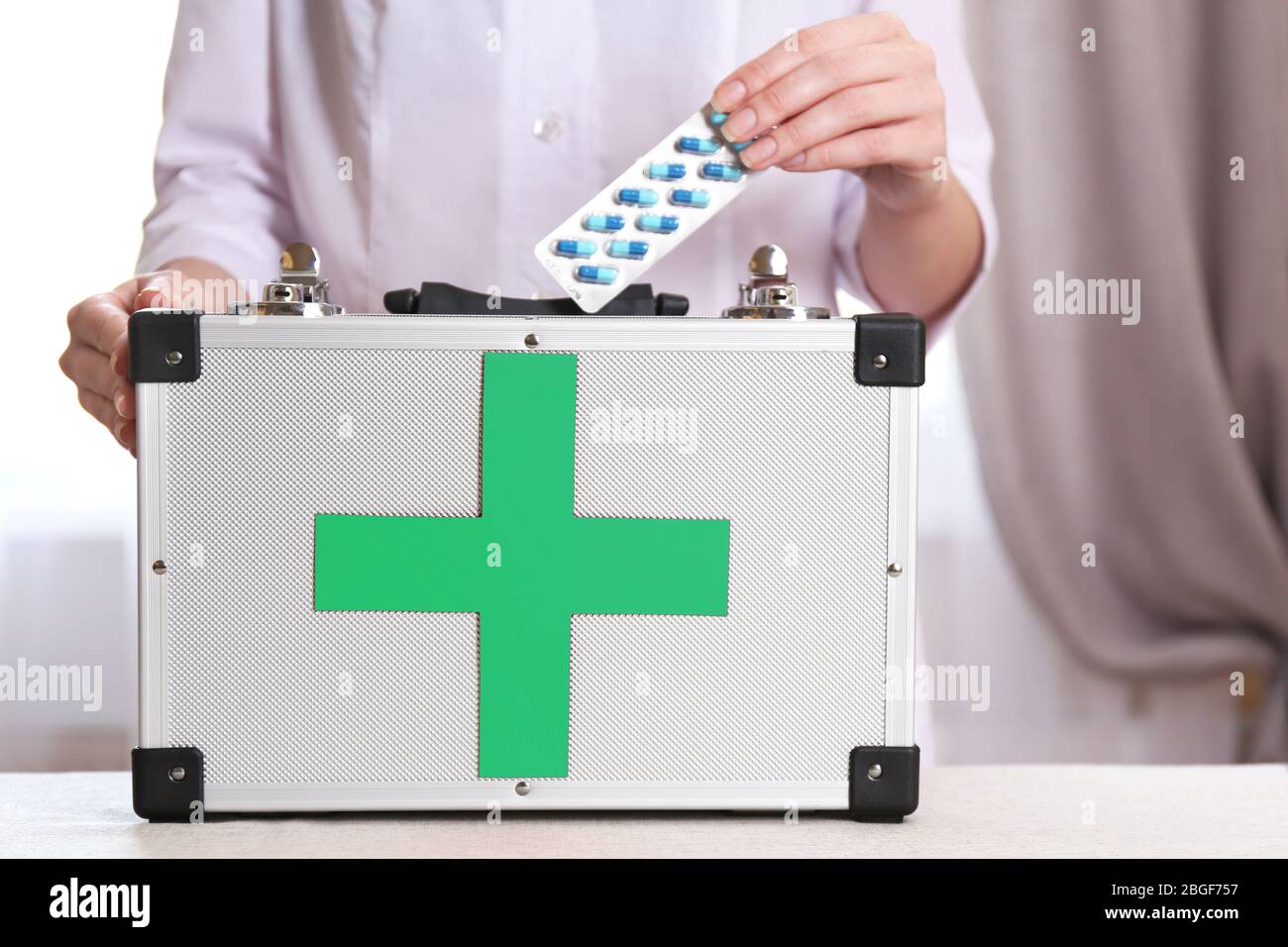 Nurse holding first aid kit in room Stock Photo - Alamy